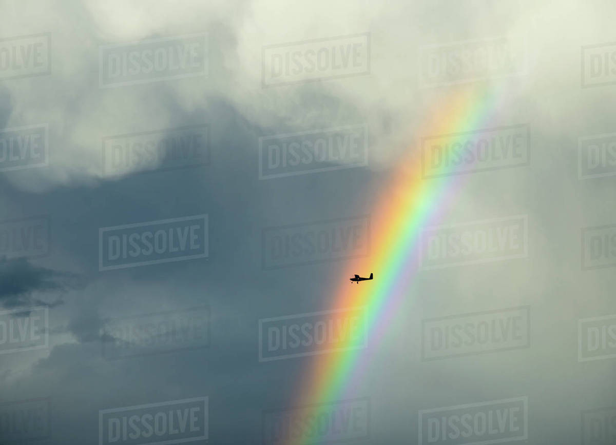 Silhouette of small plane flying through rainbow - Royalty-free Stock ...