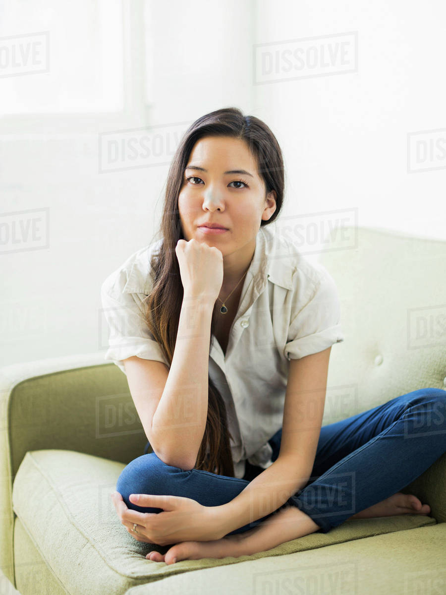 Portrait of woman sitting on sofa - Royalty-free Stock Photo | Dissolve