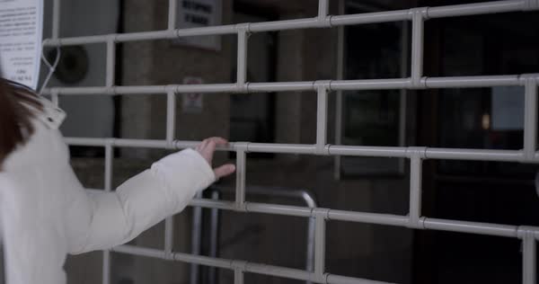 Woman with a medical mask is faced with locked doors due to coronavirus ...