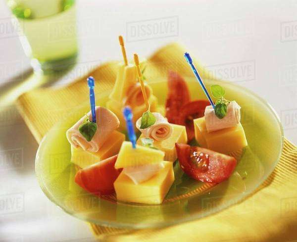Cheese and ham on cocktail sticks with tomatoes - Stock Photo - Dissolve