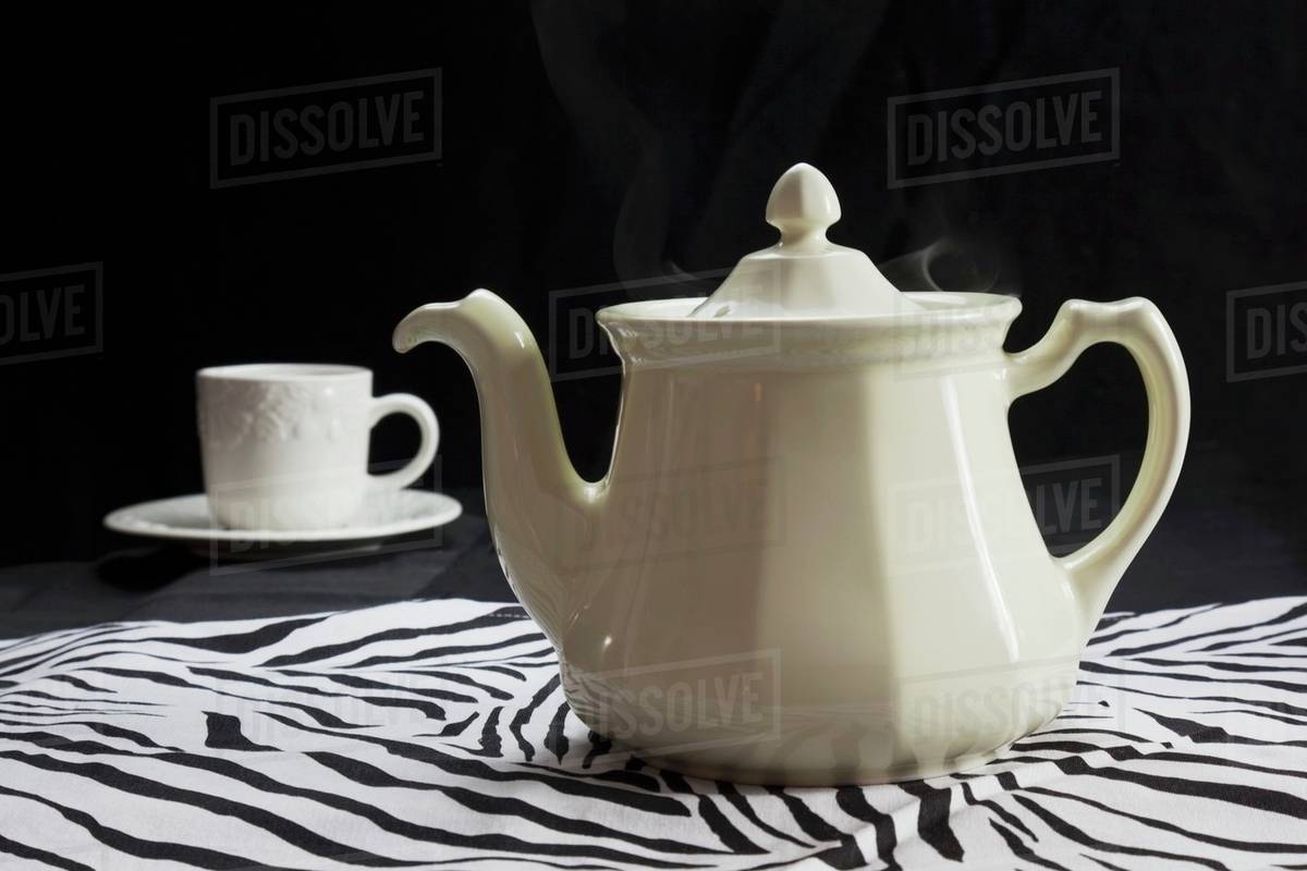 White Tea Pot and Tea Cup on Zebra Pattern Cloth - Stock Photo - Dissolve