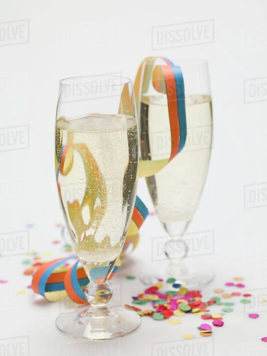 Two glasses of sparkling wine, paper streamer and confetti - Stock ...