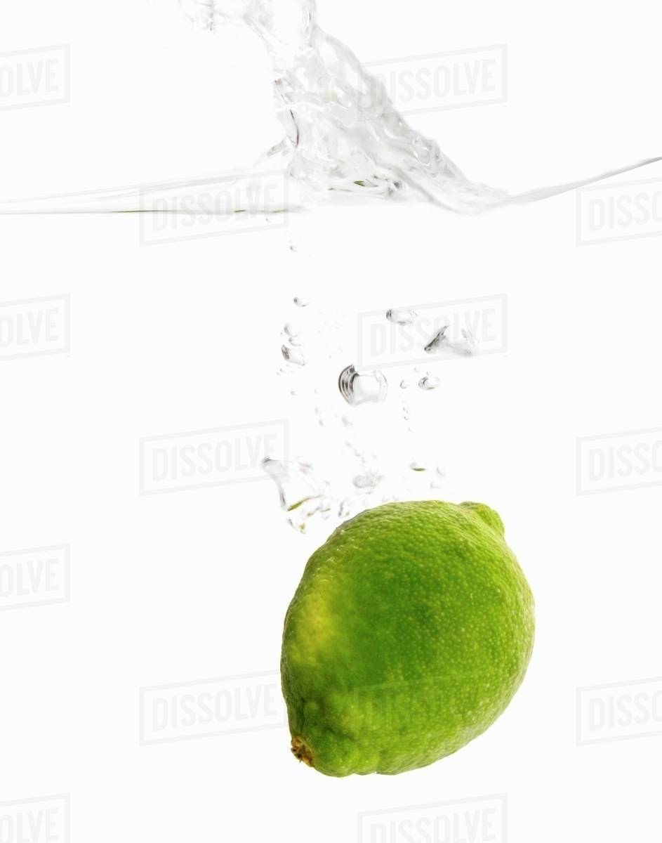 Whole Lime Dropping into Water - Stock Photo - Dissolve