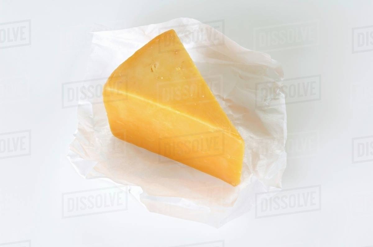 A piece of Cheddar cheese on paper - Royalty-free Stock Photo | Dissolve