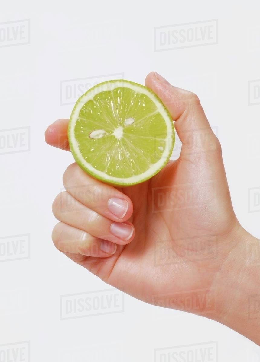 Hand holding half a lime - Royalty-free Stock Photo | Dissolve