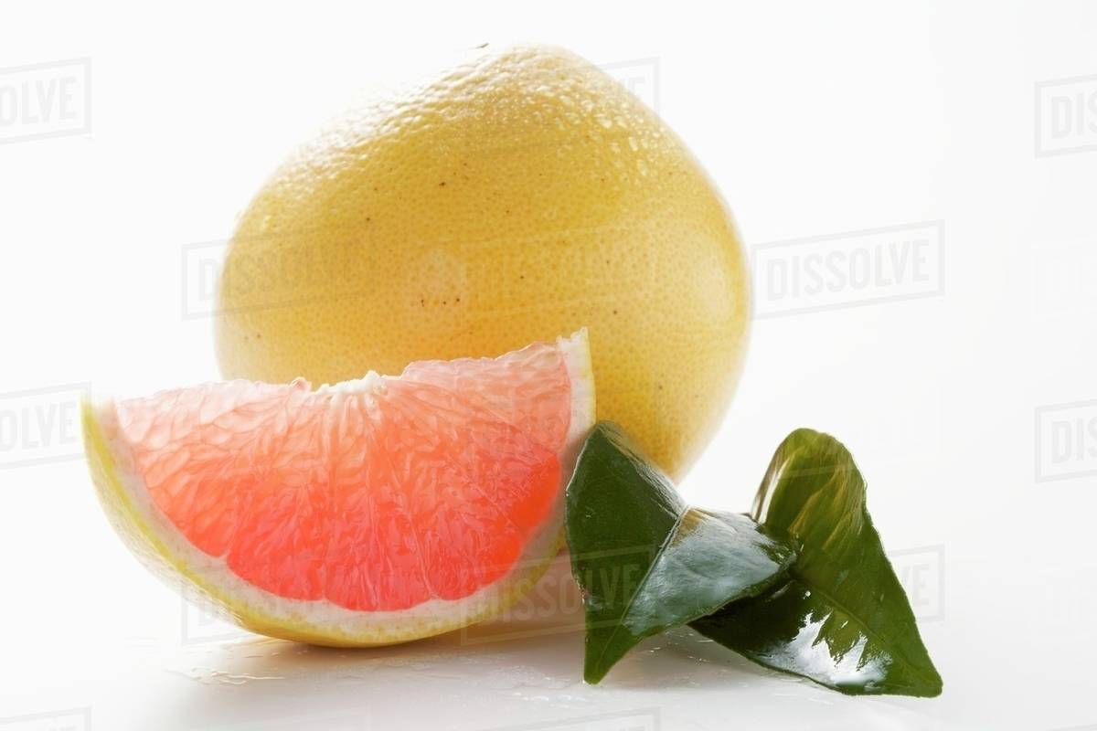 Whole grapefruit, wedge of pink grapefruit and leaves - Royalty-free ...