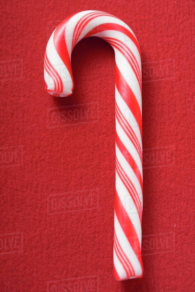 Candy cane on red background - Stock Photo - Dissolve