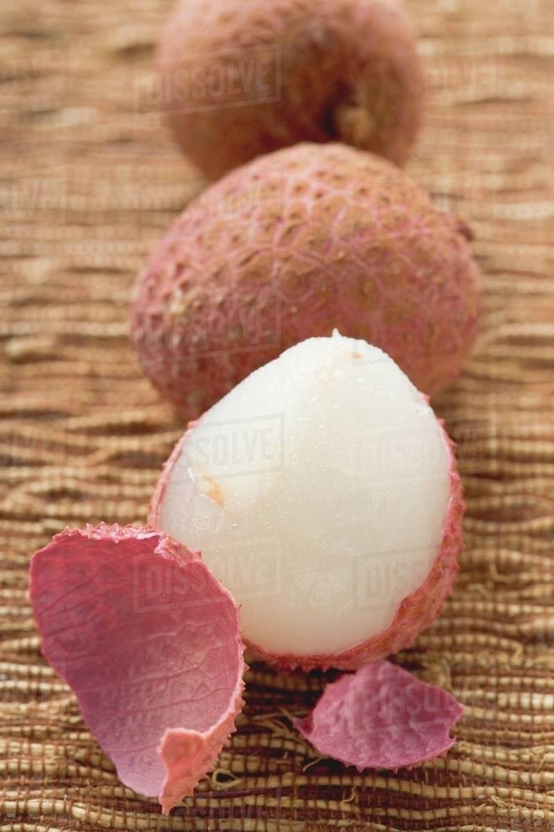 Three lychees in a row, one half-peeled - Royalty-free Stock Photo ...