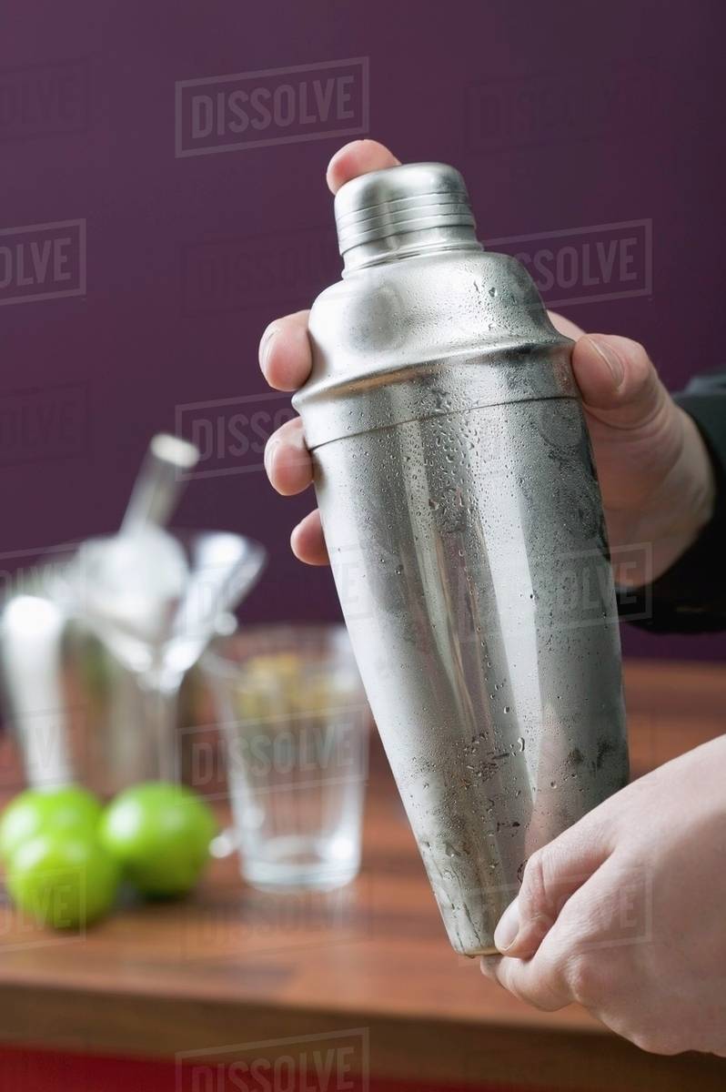 Hands holding cocktail shaker - Stock Photo - Dissolve