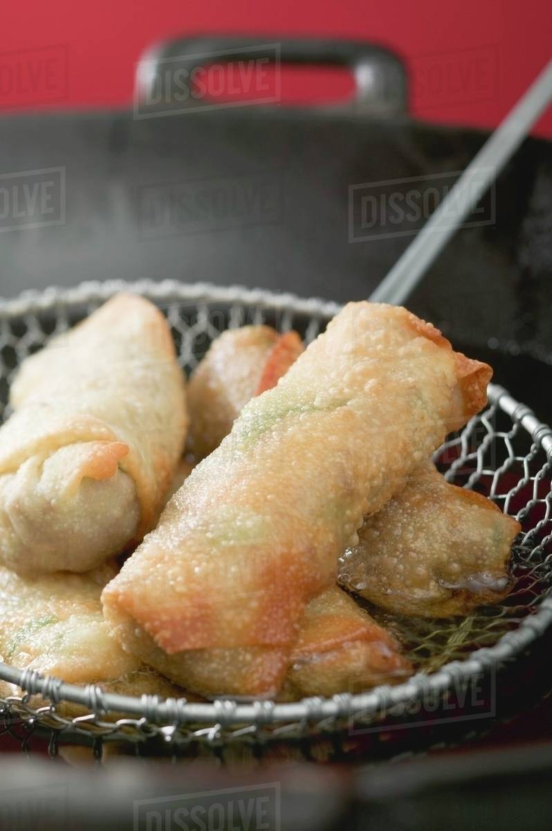 Taking deep-fried spring rolls out of wok - Royalty-free Stock Photo ...
