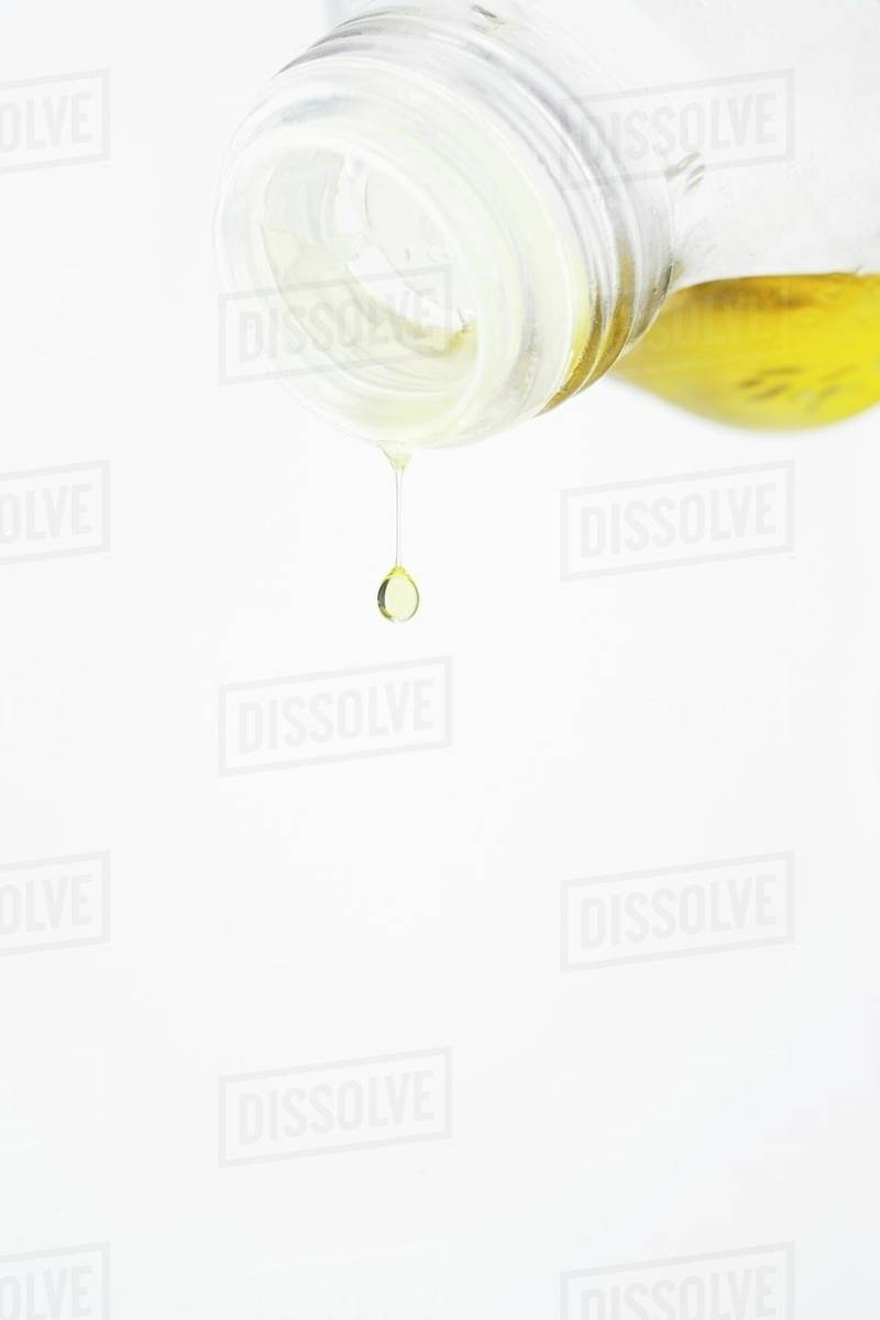 Olive oil dripping out of a bottle - Royalty-free Stock Photo | Dissolve