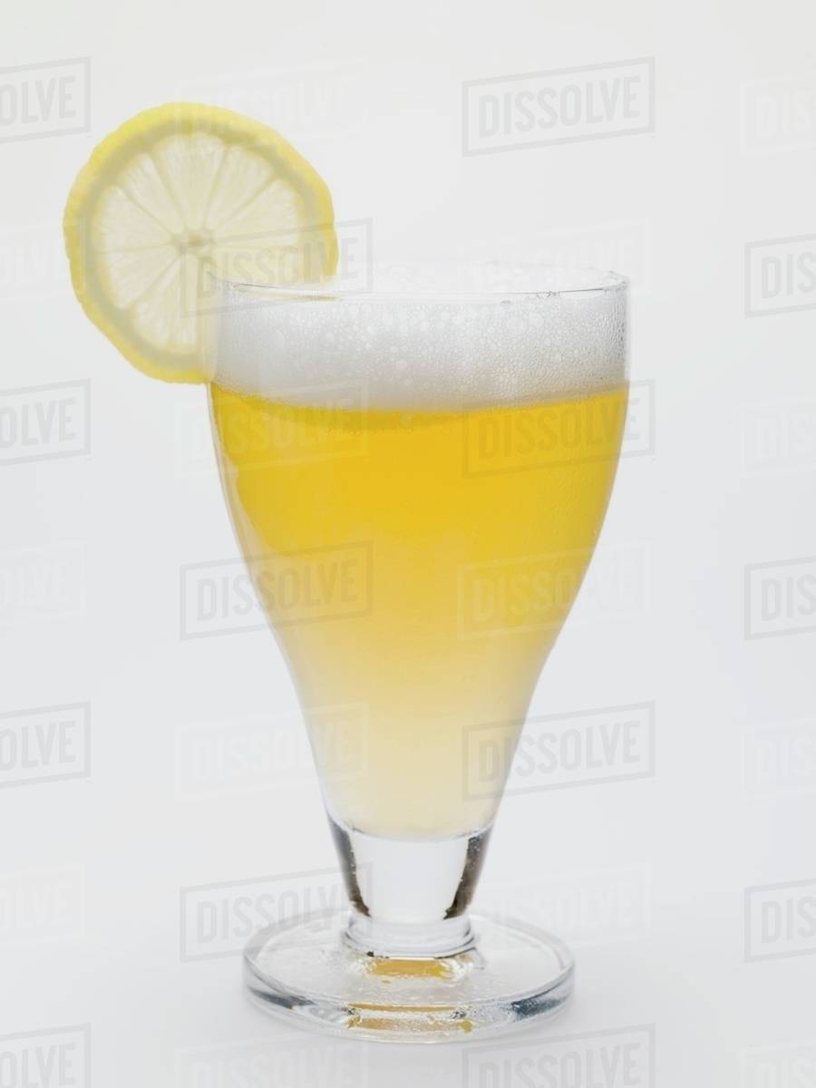 Glass of shandy with slice of lemon (UK) - Stock Photo - Dissolve