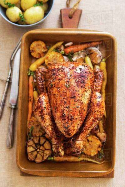 Roast chicken with garlic and root vegetables (seen from above ...