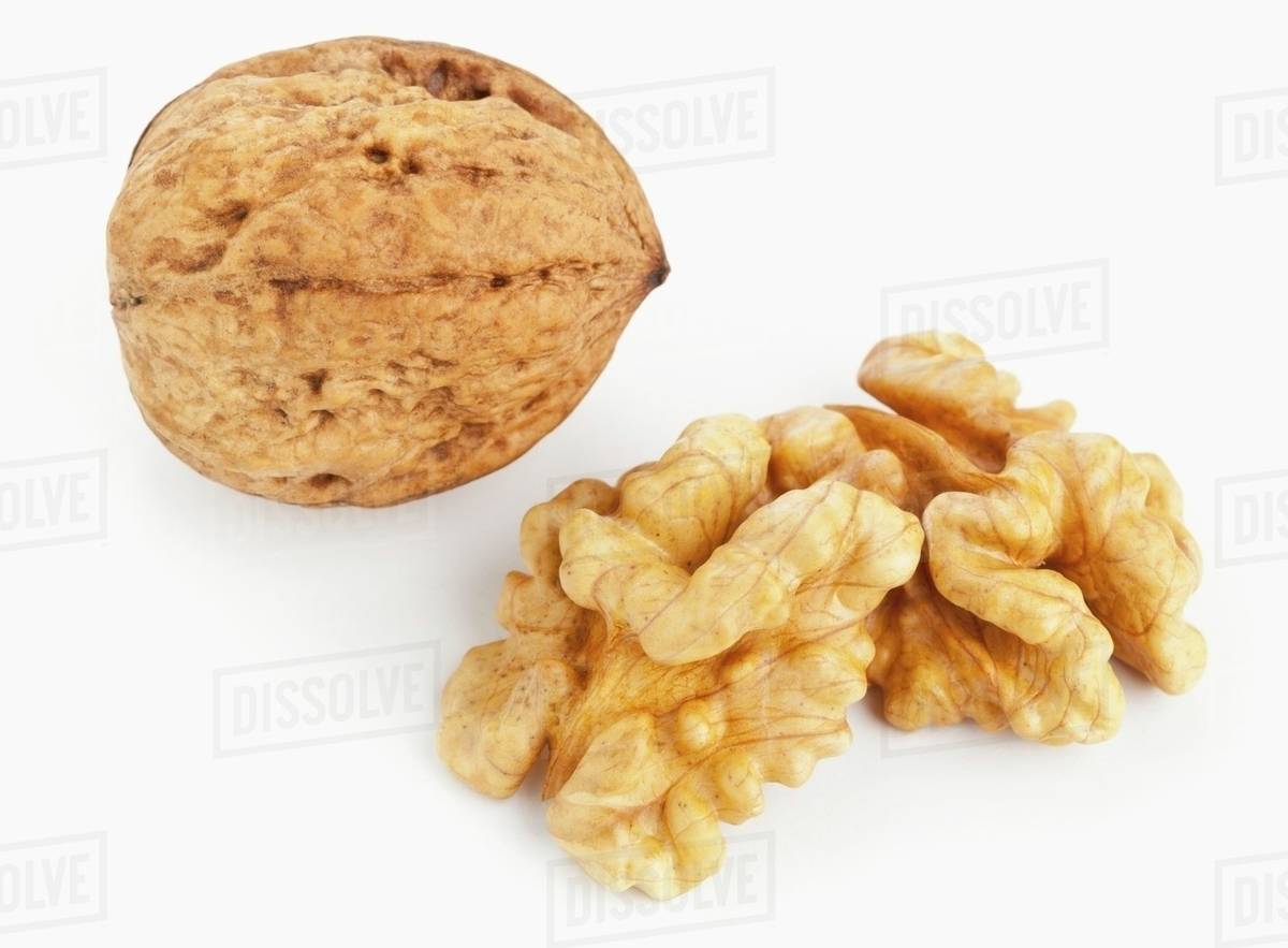 A whole walnut in its shell and two walnut halves - Royalty-free Stock ...