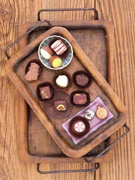 Various chocolate pralines on a wooden tray - Stock Photo - Dissolve