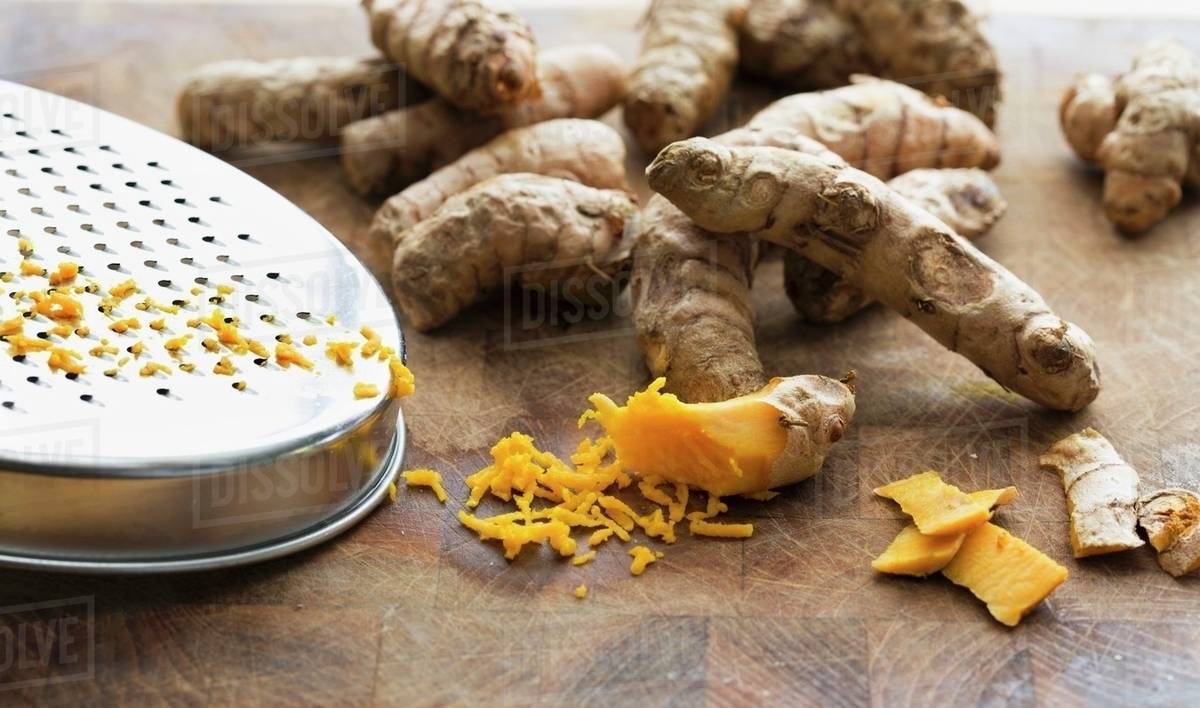 Fresh turmeric roots with a grater - Royalty-free Stock Photo | Dissolve