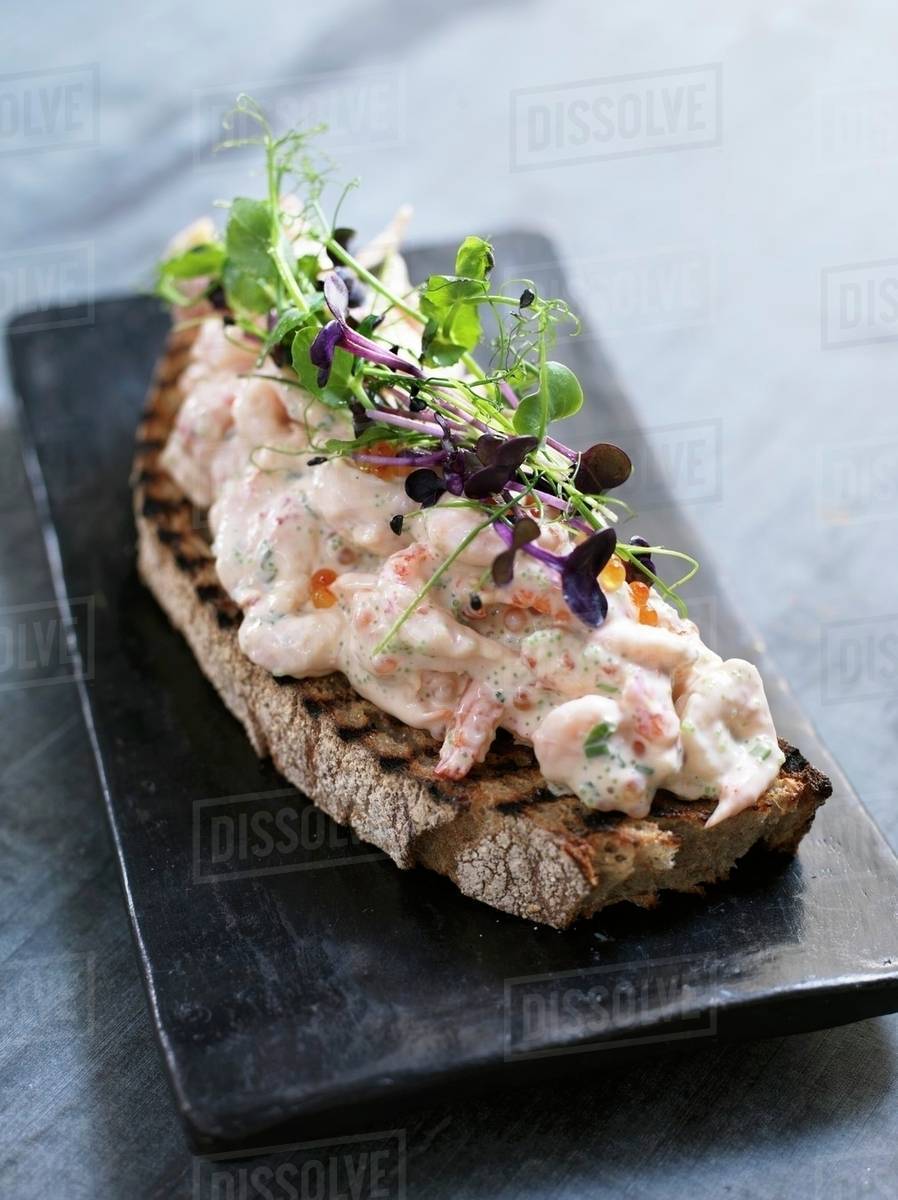 An open sandwich topped with prawn salad - Stock Photo - Dissolve