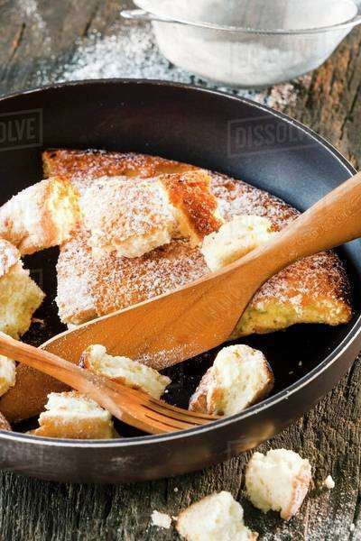 Kaiserschmarren (shredded sugared pancake from Austria) being shredded ...