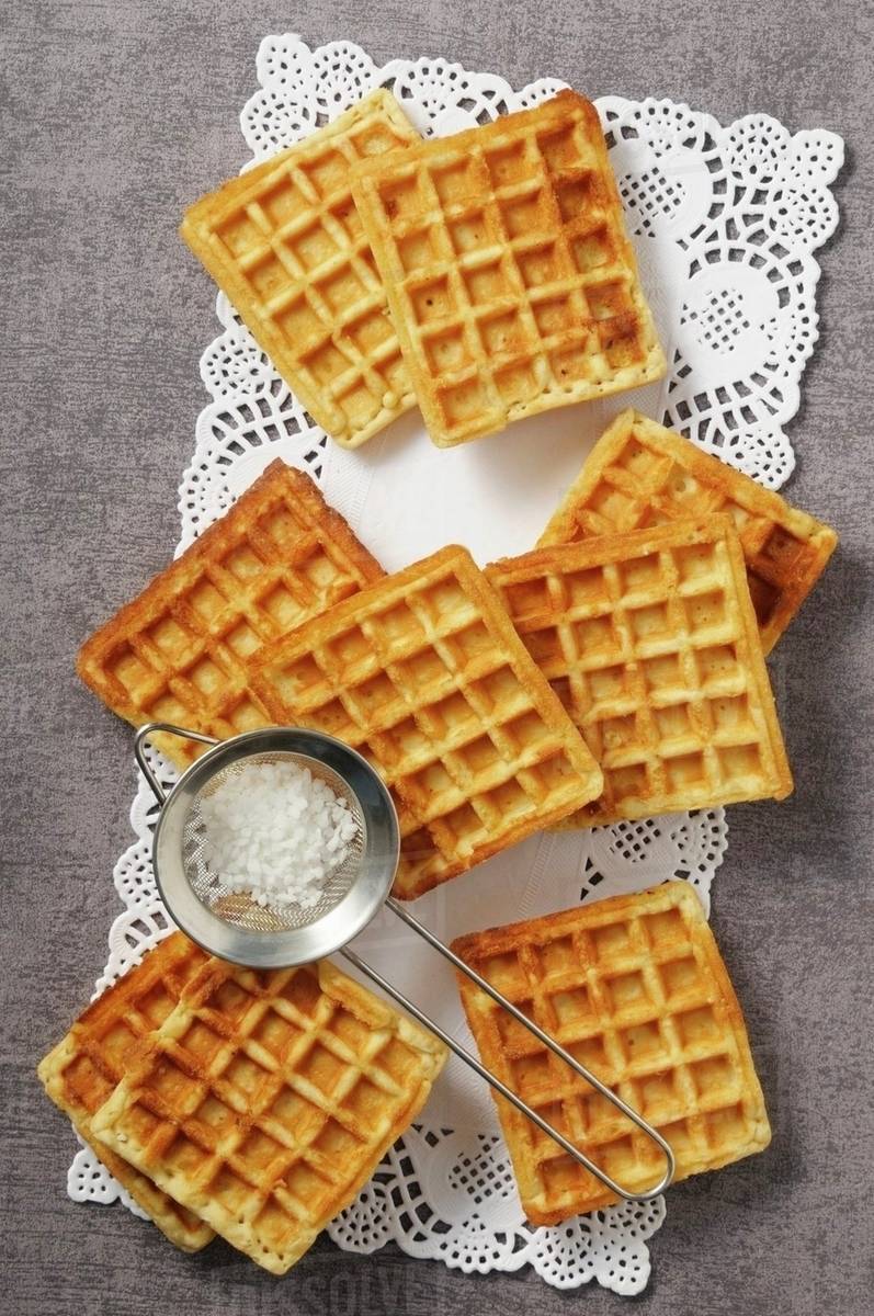 Waffles and a sieve of icing sugar on a doily - Royalty-free Stock ...