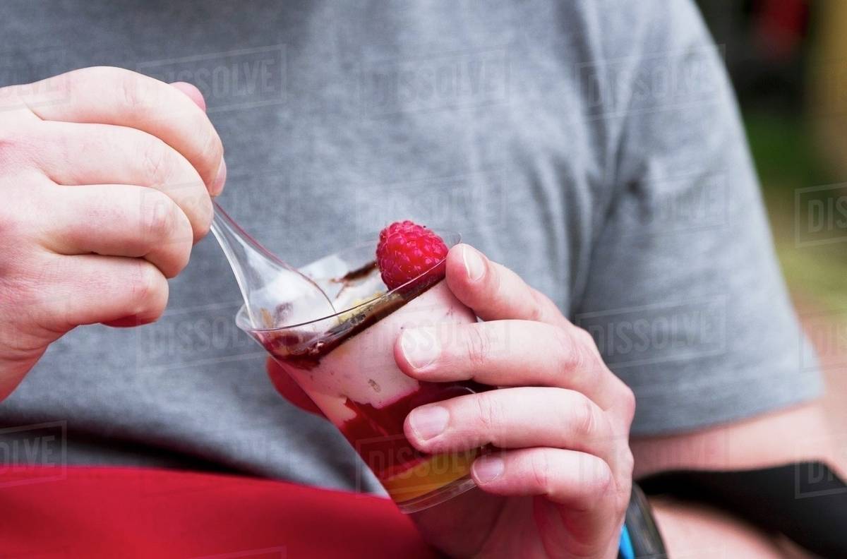 A man eating a raspberry cream dessert - Stock Photo - Dissolve