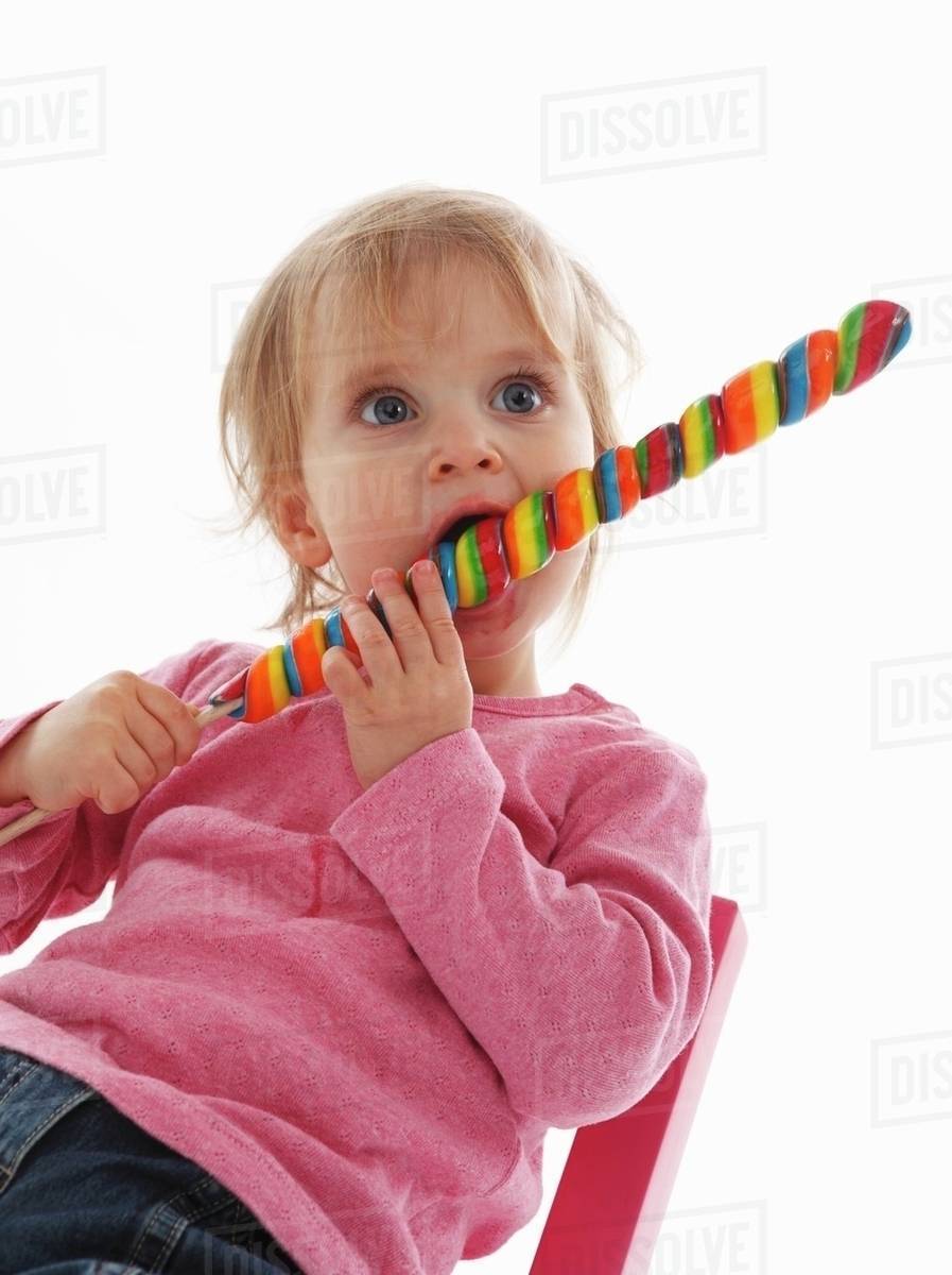 A small child eating a giant lolly - Stock Photo - Dissolve