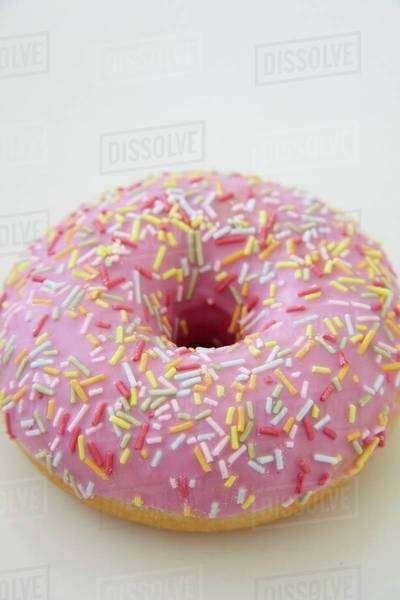 A pink iced doughnut with sugar sprinkles - Royalty-free Stock Photo ...
