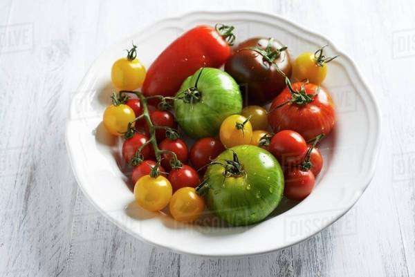 Various different coloured tomatoes on a white plate - Stock Photo ...