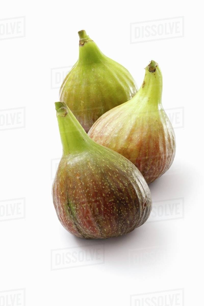Three fresh figs on a white surface - Royalty-free Stock Photo | Dissolve