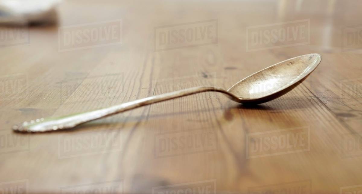 A silver spoon on a wooden table - Royalty-free Stock Photo | Dissolve