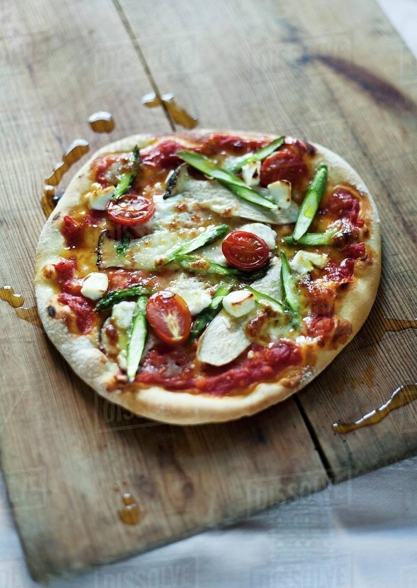 A pizza topped with king trumpet mushrooms, asparagus, goat's cheese ...