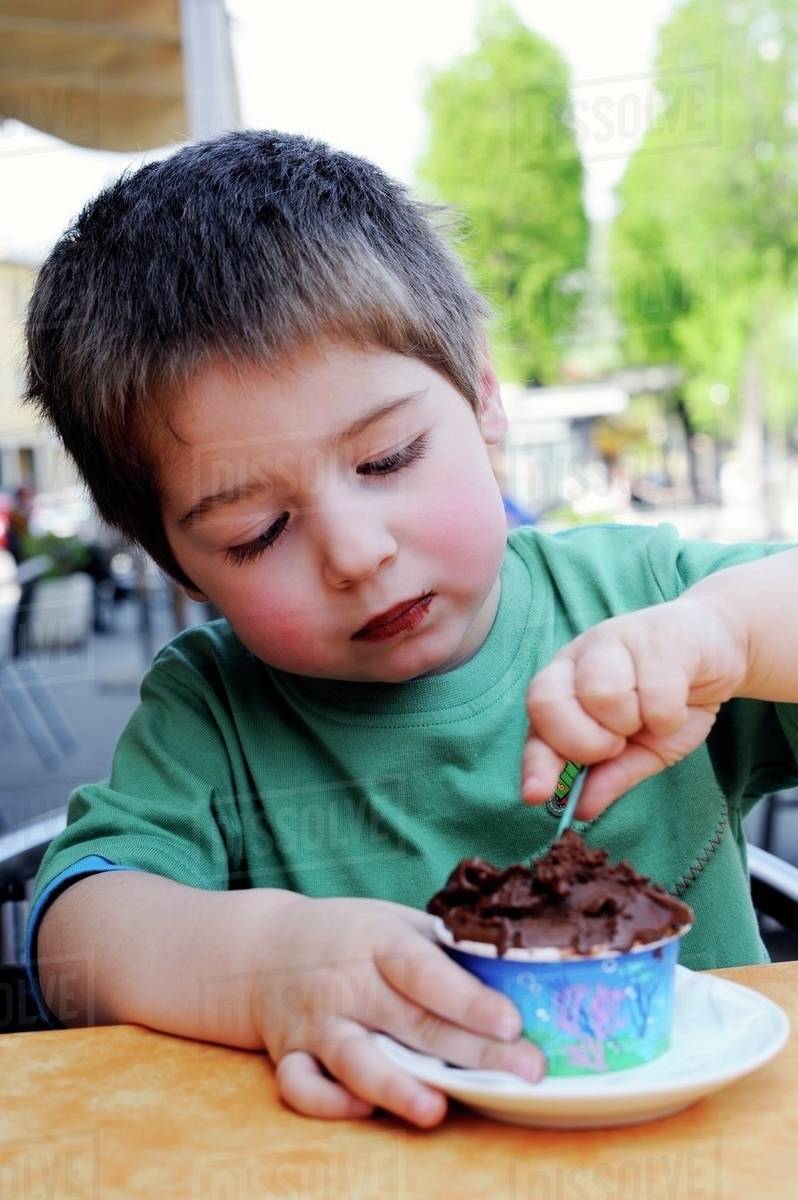 A little boy eating chocolate ice cream in an ice cream cafe - Royalty ...