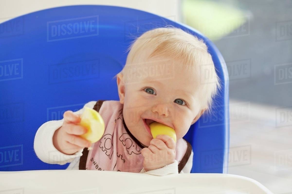 A baby eating an apple - Royalty-free Stock Photo | Dissolve