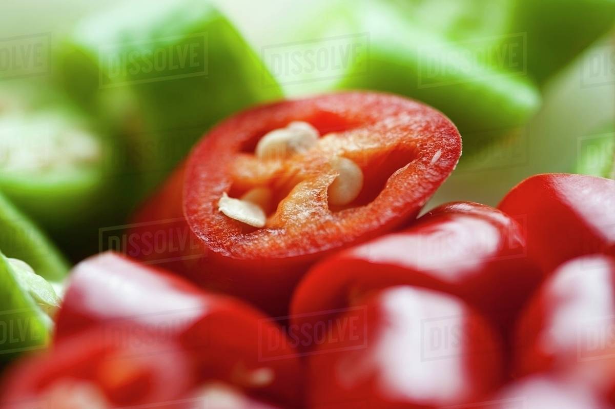 Red and green chilli peppers, sliced (close-up) - Stock Photo - Dissolve