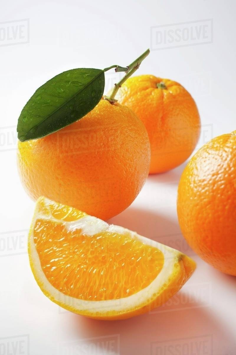 An orange wedge and whole oranges - Royalty-free Stock Photo | Dissolve