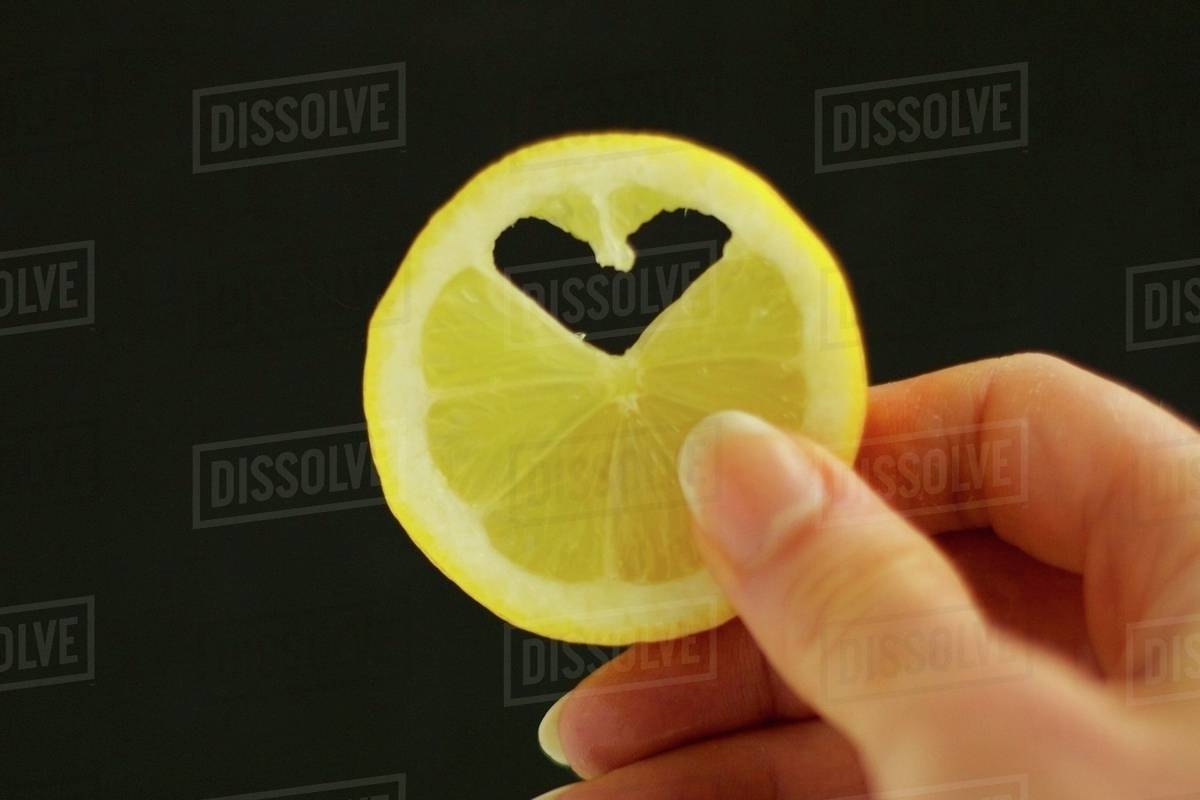A slice of lemon with a heart-shaped piece cut out of it - Royalty-free ...