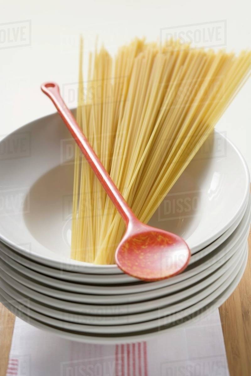 Spaghetti with cooking spoon on pile of plates - Royalty-free Stock ...