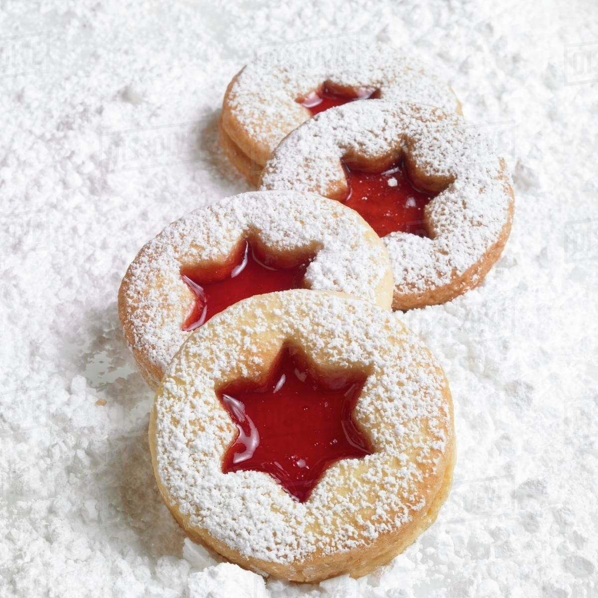 Four Linzer biscuits on icing sugar - Royalty-free Stock Photo | Dissolve