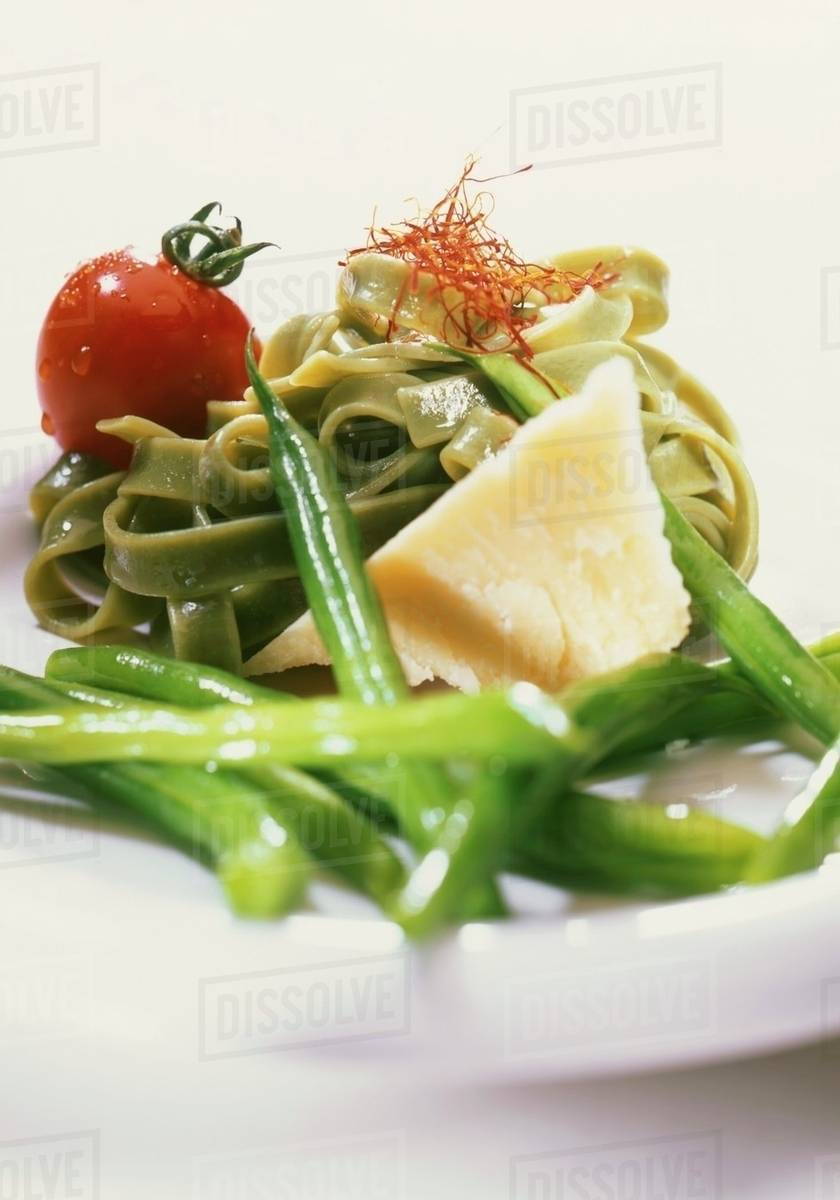 Green ribbon pasta, beans, Parmesan, saffron and tomato - Royalty-free ...