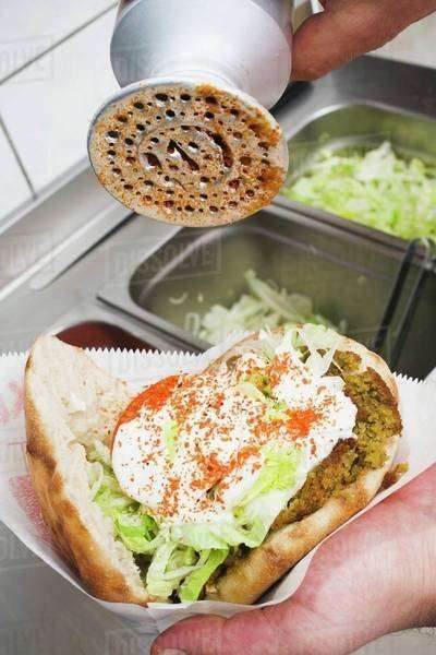 Adding spicy seasoning to a doner kebab - Stock Photo - Dissolve
