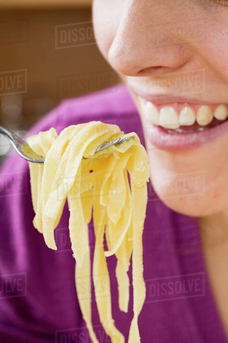 Woman eating ribbon pasta - Royalty-free Stock Photo | Dissolve