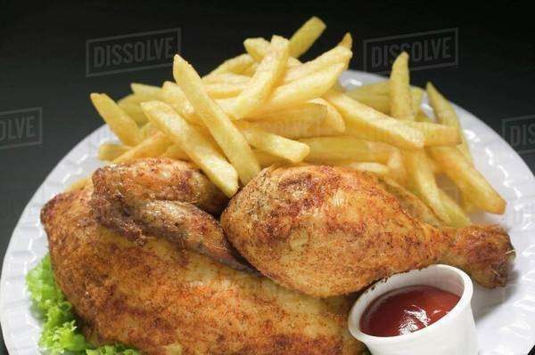 Half a chicken with chips and ketchup - Royalty-free Stock Photo | Dissolve
