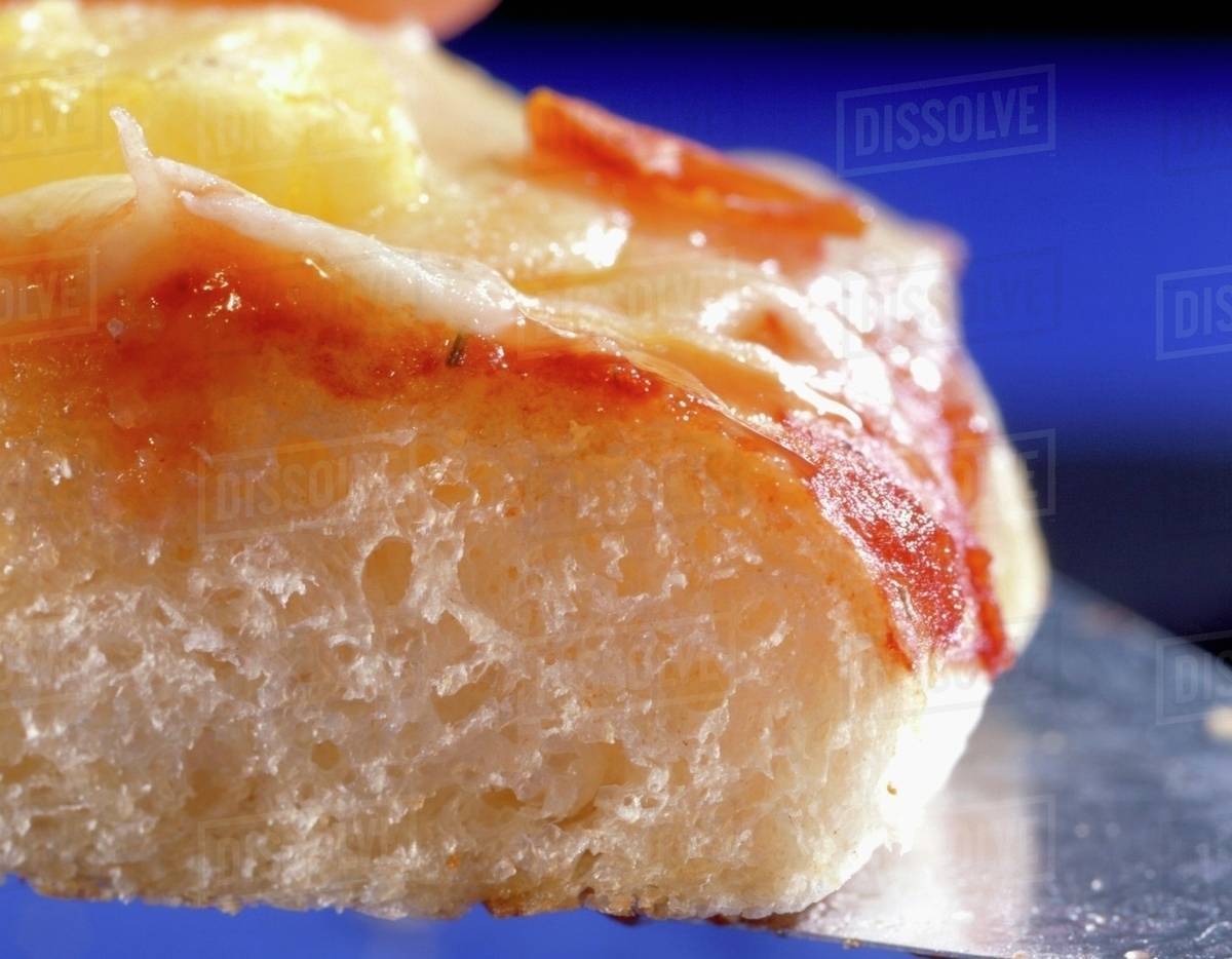 A slice of pizza showing bread base - Royalty-free Stock Photo | Dissolve