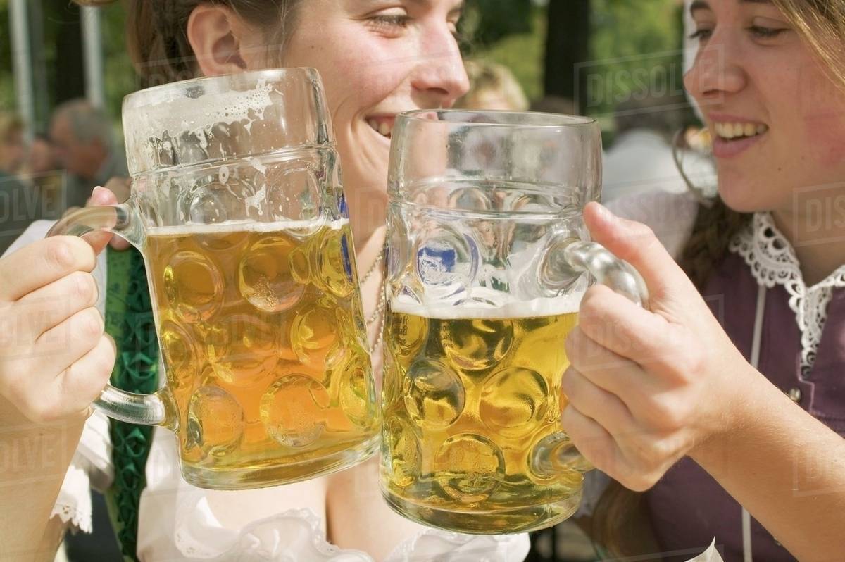 Two women clinking litres of beer at Oktoberfest - Royalty-free Stock ...