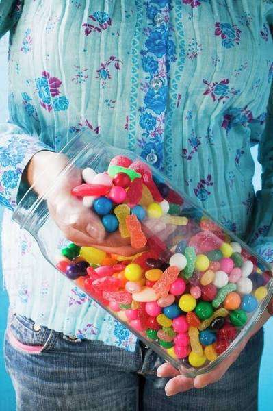 Hand taking sweets out of jar - Royalty-free Stock Photo | Dissolve
