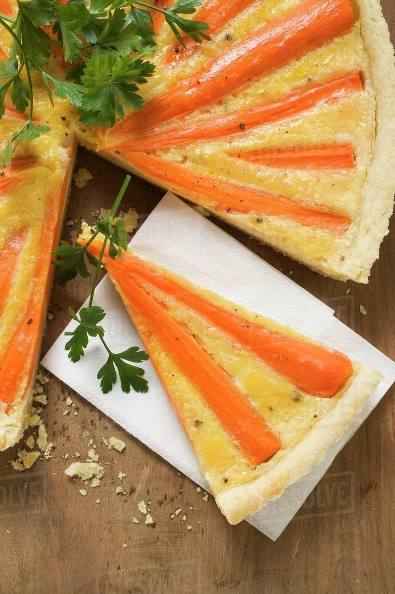 Carrot tart with parsley, a slice cut - Stock Photo - Dissolve