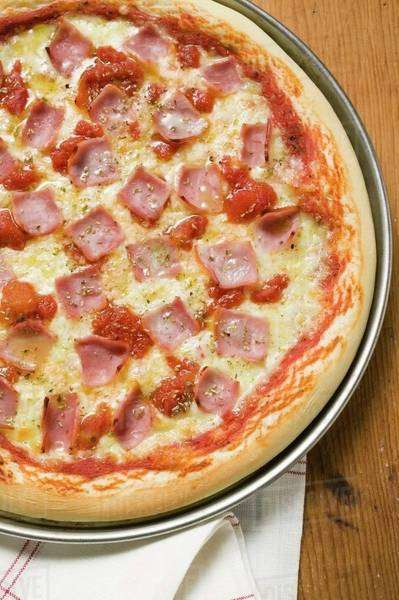 Ham, cheese and tomato pizza (detail) - Stock Photo - Dissolve