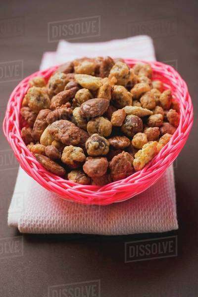 Mixed nuts to nibble in pink basket - Royalty-free Stock Photo | Dissolve