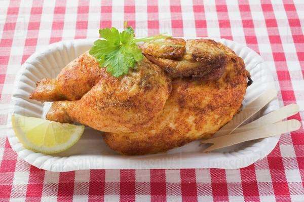 Half a roast chicken in paper dish - Royalty-free Stock Photo | Dissolve