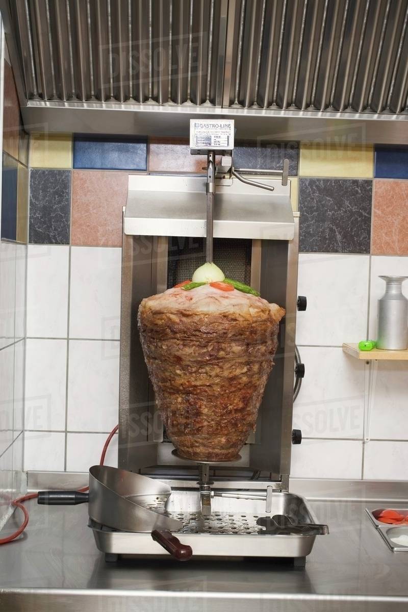 Doner kebab on spit in the kitchen of a snack bar - Stock Photo - Dissolve