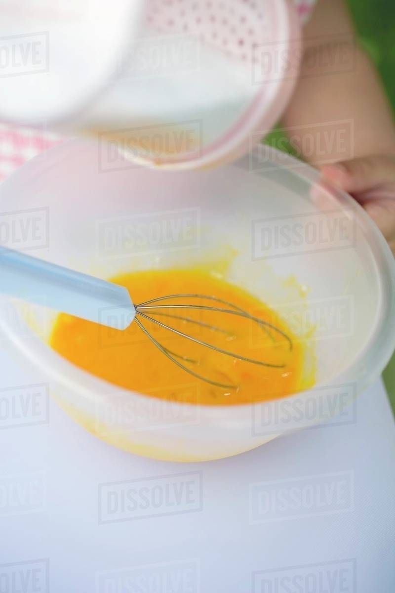 Child whisking egg yolks - Stock Photo - Dissolve